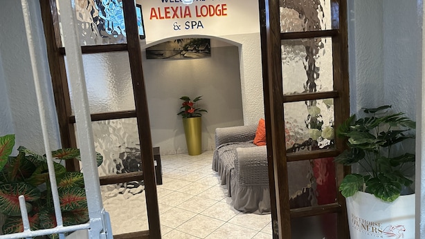 Uma área de recepção com uma placa que diz "Welcome to Alexia Lodge & Spa".