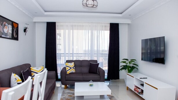 Uma sala de estar moderna com sofá, mesa de centro e televisão.