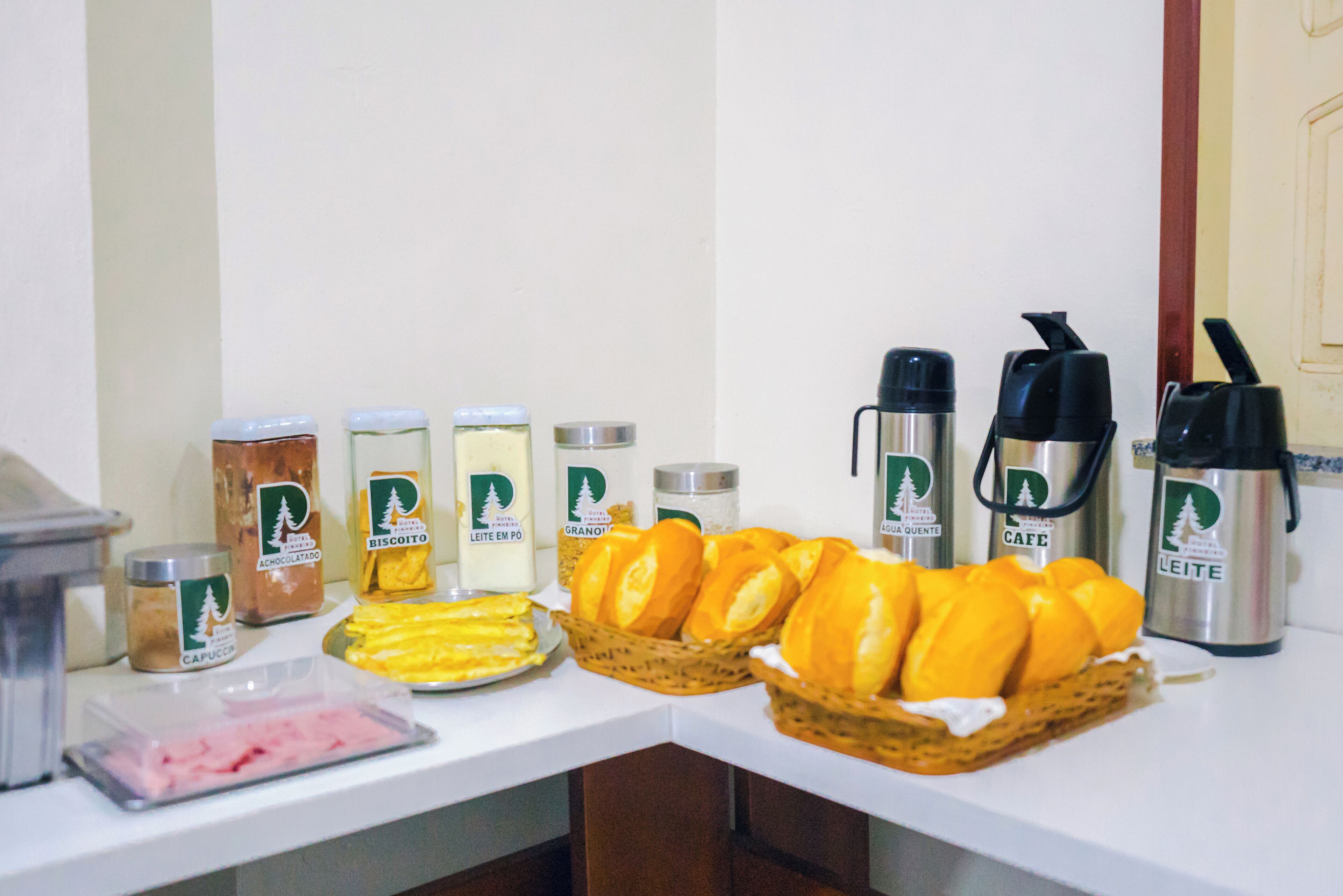 Um buffet de café da manhã com diversas opções de alimentos e bebidas.