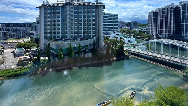 Um hotel moderno com vista desobstruída para a paisagem urbana e um rio.