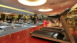 Uma academia moderna com esteiras, aparelhos de musculação e bolas de exercício.