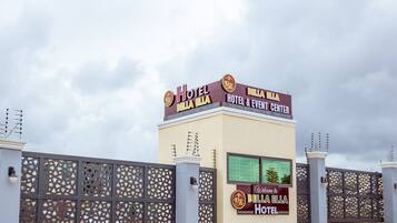 Placa de hotel com a inscrição 'Bella Ella Hotel & Event Center' e números de contato.