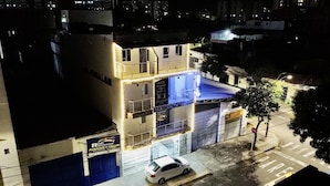 Um edifício de vários andares com uma placa indicando 'Hotel Diamond BCA' e um carro visível estacionado na frente.