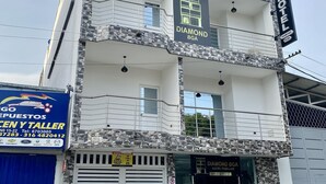 Um edifício de vários andares com uma placa indicando 'Hotel Diamond BGA' e uma entrada de garagem visível.