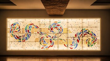 Um interior moderno com uma grande instalação de arte abstrata em uma parede.
