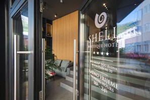 Entrada do Shell Boutique Hotel, com decoração moderna, um sofá e uma escada.