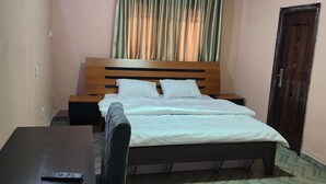 Quarto com cama, escrivaninha e cadeira.
