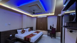 Quarto de hotel moderno com uma cama grande, uma escrivaninha e uma televisão.