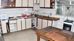 Cozinha com armários de madeira, micro-ondas, fogão e pia.