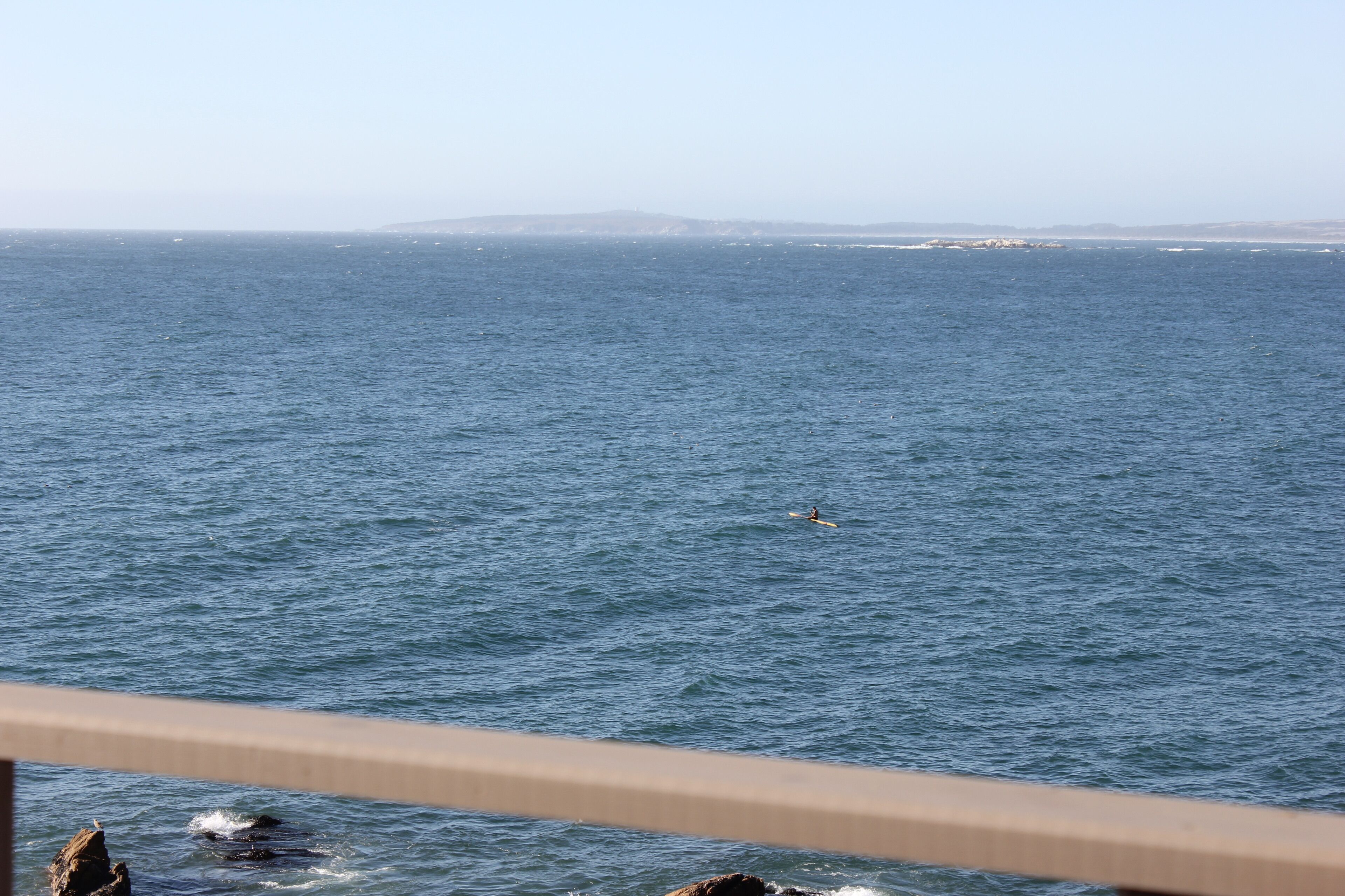 Vista do oceano a partir de uma varanda com guarda-corpo.