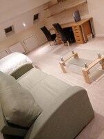 Quarto moderno com uma cama, uma escrivaninha e duas cadeiras.