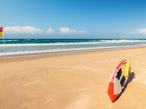 Uma praia com posto de salva-vidas e bandeira.