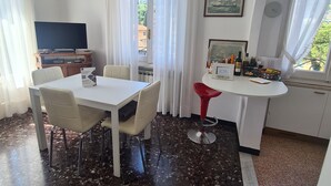 Cozinha moderna com área de refeições, televisão e vista para o exterior.