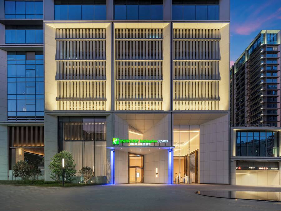 Um edifício de hotel moderno com entrada imponente, janelas amplas e fachada bem iluminada.