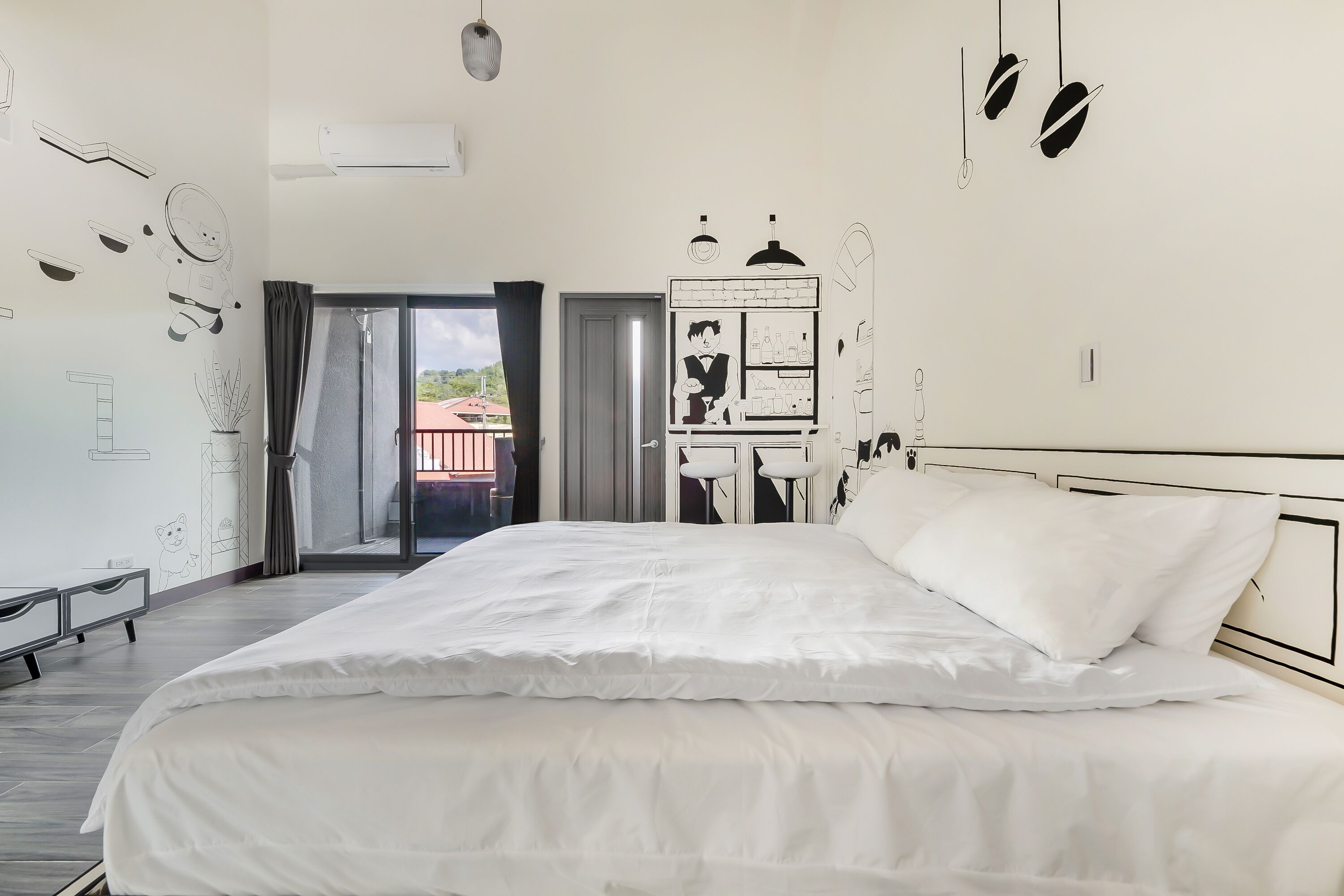 Quarto de hotel moderno com uma cama grande, uma escrivaninha e vista para o exterior.
