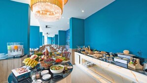 Buffet com diversos pratos e um lustre moderno.