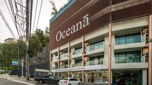 Um edifício com vários andares e uma placa de destaque com a inscrição 