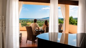 Um casal jantando à mesa com vista para a paisagem.