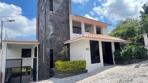 Uma casa moderna de dois andares com fachada de pedra, telhado telhado e entrada com portão.