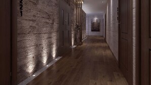 Um corredor com parede texturizada, portas de madeira e um quadro pendurado na parede.