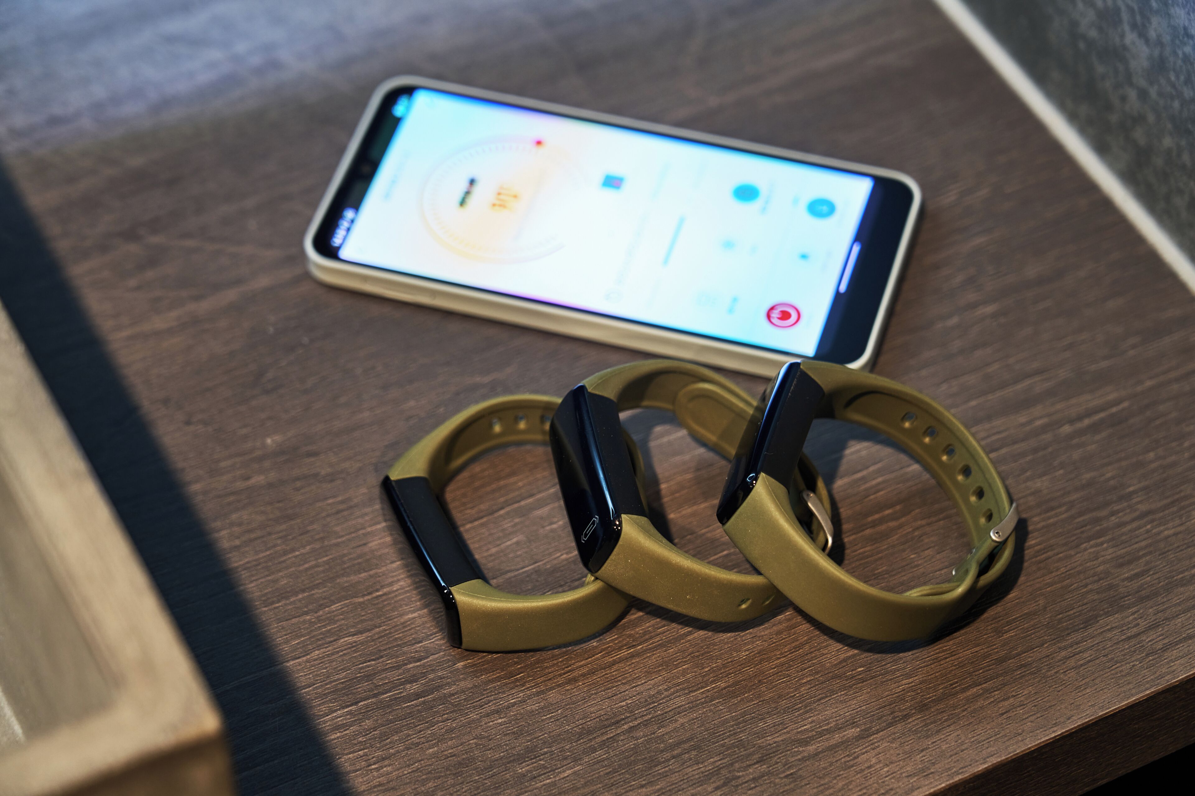 Um smartphone exibe um aplicativo de monitoramento de atividades físicas sobre uma superfície de madeira.