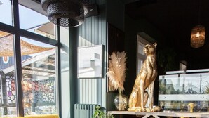Um quarto aconchegante com uma mesa de madeira, cadeiras estampadas e uma janela grande com vista.