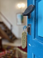 Uma porta azul com uma fechadura e um chaveiro com etiqueta.
