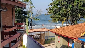 Vista costeira com um edifício, uma praia e céu claro.