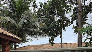 Um edifício à beira-mar com telhado em azulejos, entrada com portão e vista para o mar.