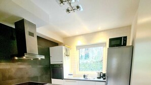 Uma cozinha moderna com ilha central, eletrodomésticos embutidos e uma grande janela que proporciona luz natural.