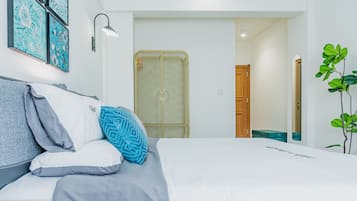 Quarto moderno com uma cama grande, um guarda-roupa e uma planta.