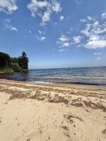 Uma praia com céu claro e águas calmas.