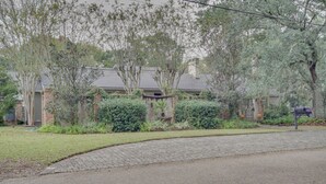 Rua residencial com casas, calçada de entrada e caixa de correio.
