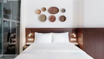 Quarto de hotel com cama, cabeceira, mesas de cabeceira e coleção de cestos fixados na parede.