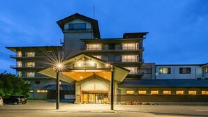 Um hotel com vários andares, uma entrada imponente e uma estrutura semelhante a uma torre.
