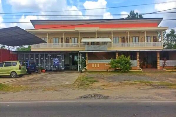 Um edifício de dois andares com teto plano e varanda no andar superior.