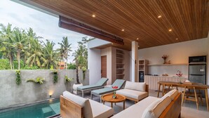 Uma área externa moderna com piscina, espreguiçadeiras e uma mesa de jantar de madeira.