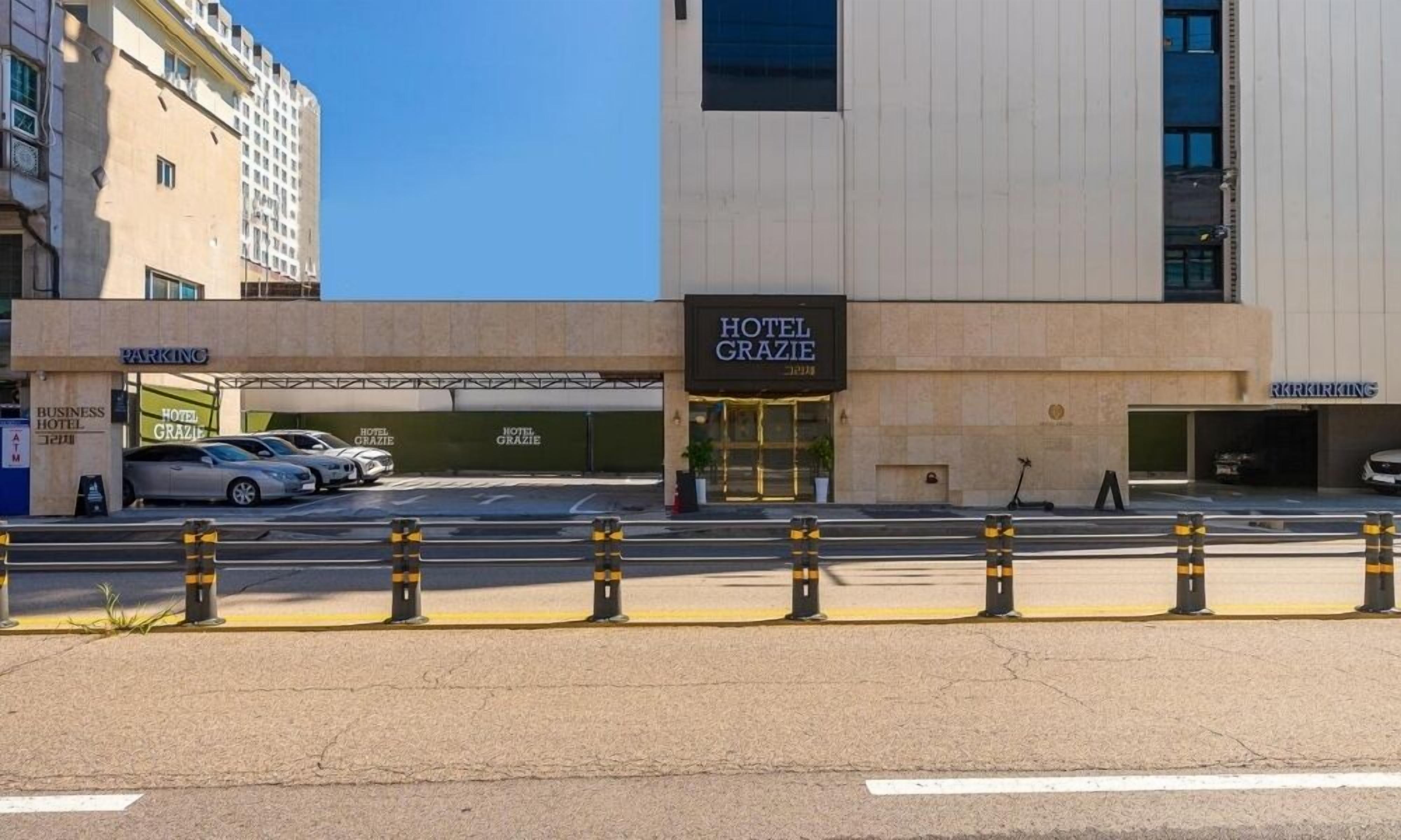 Um hotel chamado 'Hotel Grazie', com uma área de estacionamento e um hotel executivo adjacente.