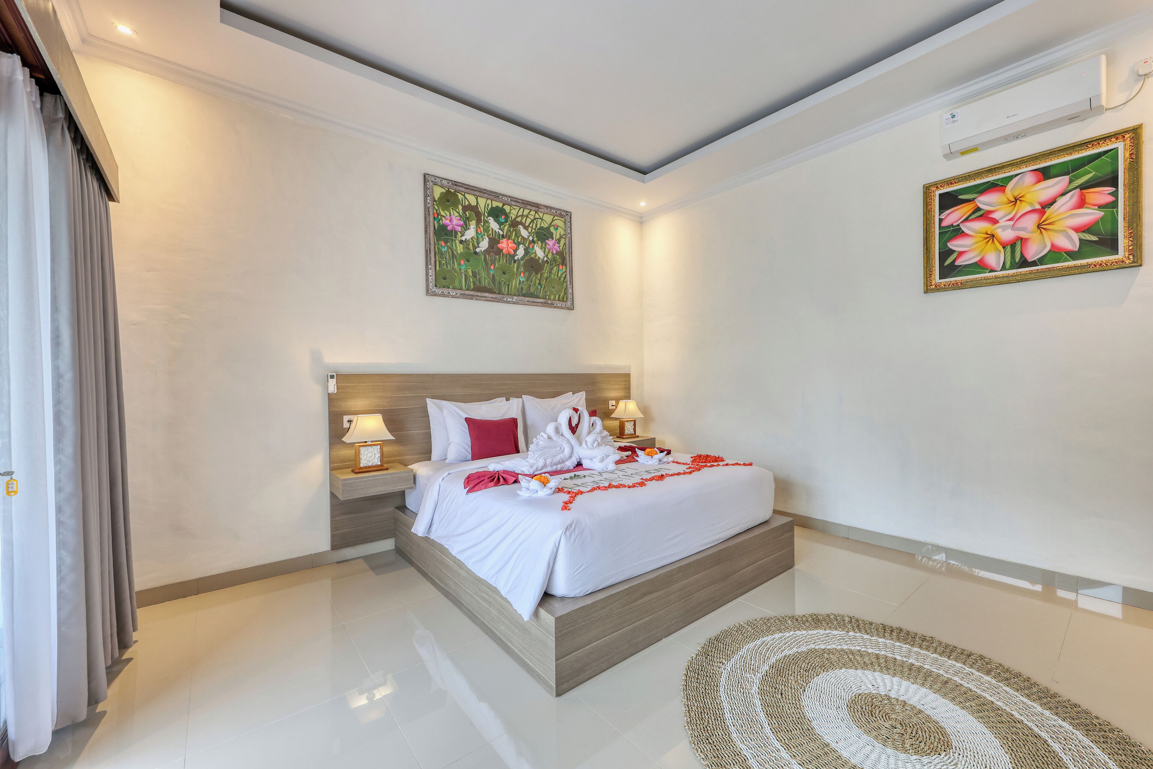 Quarto de hotel moderno com uma cama grande, uma cabeceira de madeira e duas mesas de cabeceira com luminárias.