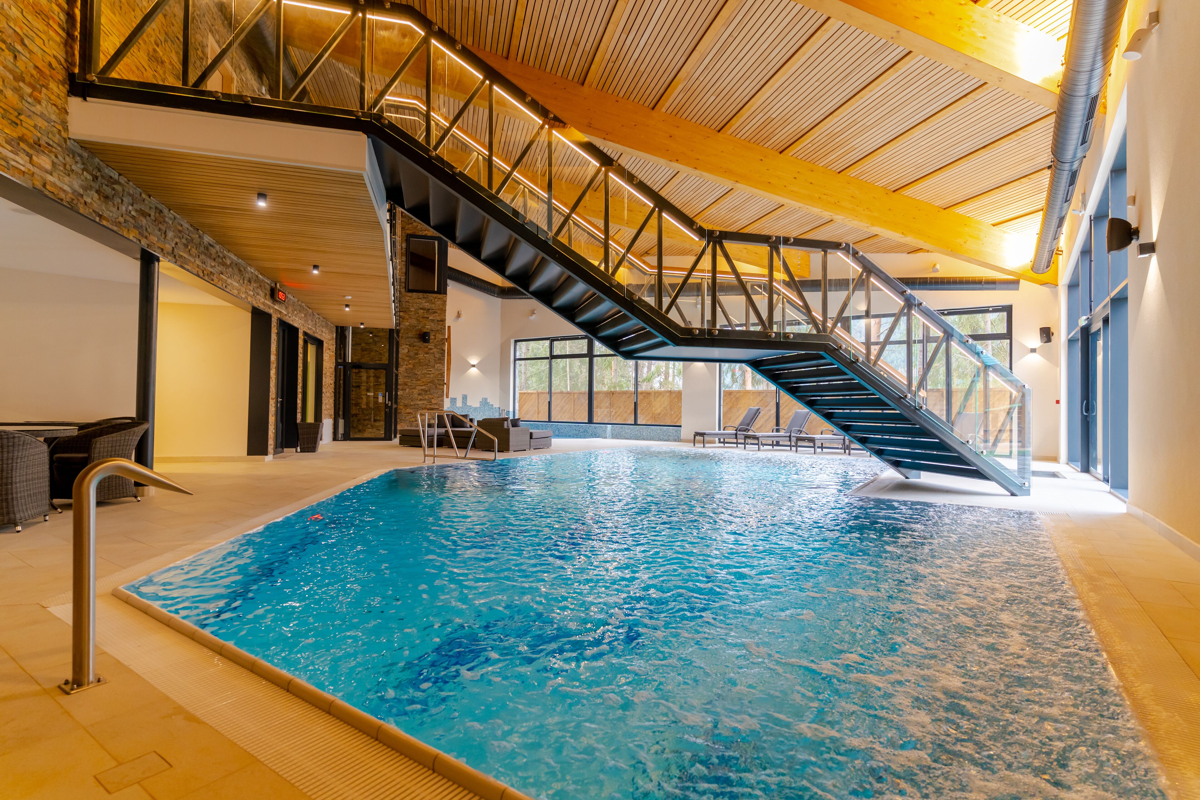 Piscina interior com escadaria que leva a um andar superior.