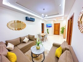 Apartamento conforto | Área de estar | TV de tela plana 65 polegadas com canais via satélite, Netflix