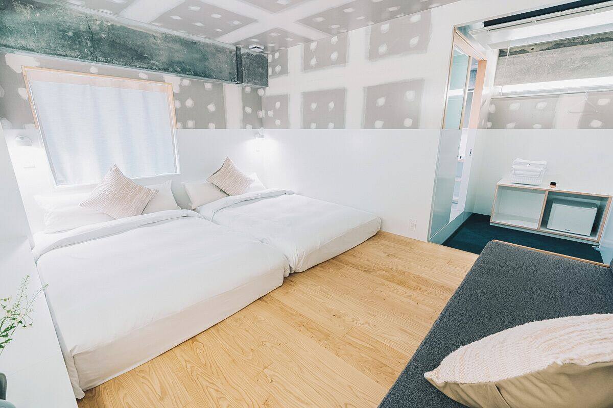 Um quarto com uma cama, uma escrivaninha e uma janela.