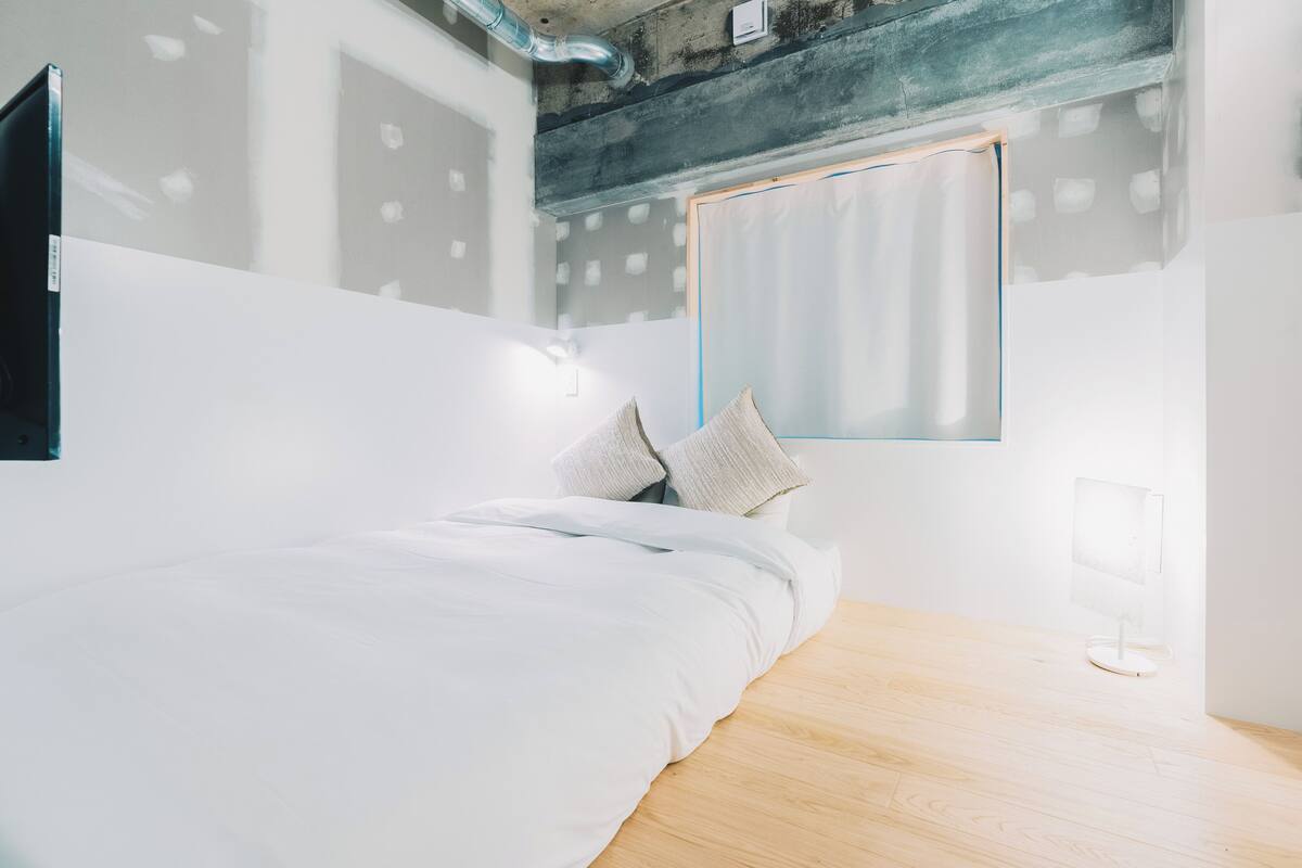 Quarto com uma cama, uma janela e uma mesa de cabeceira.