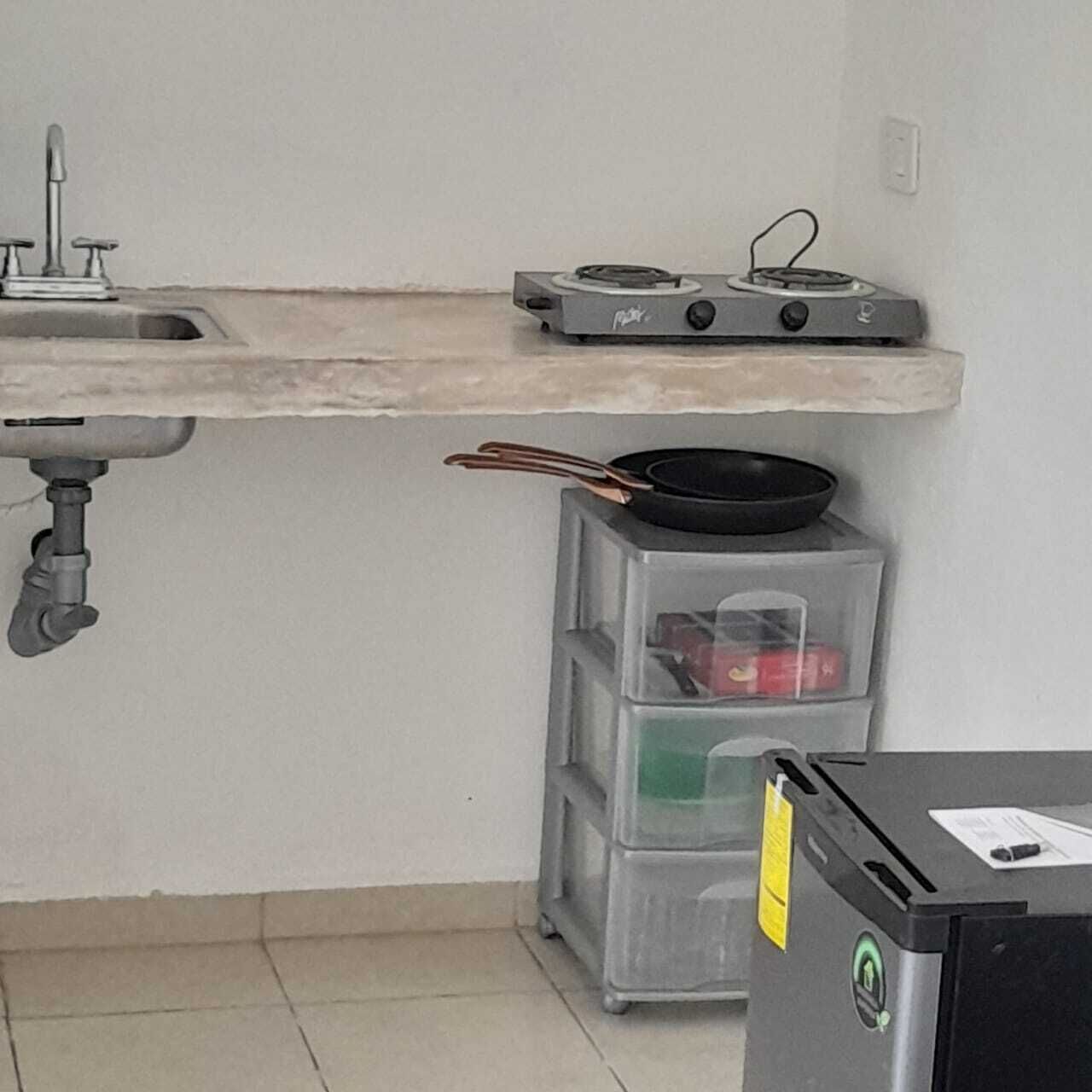 Uma cozinha com pia, fogão, panela e armário.