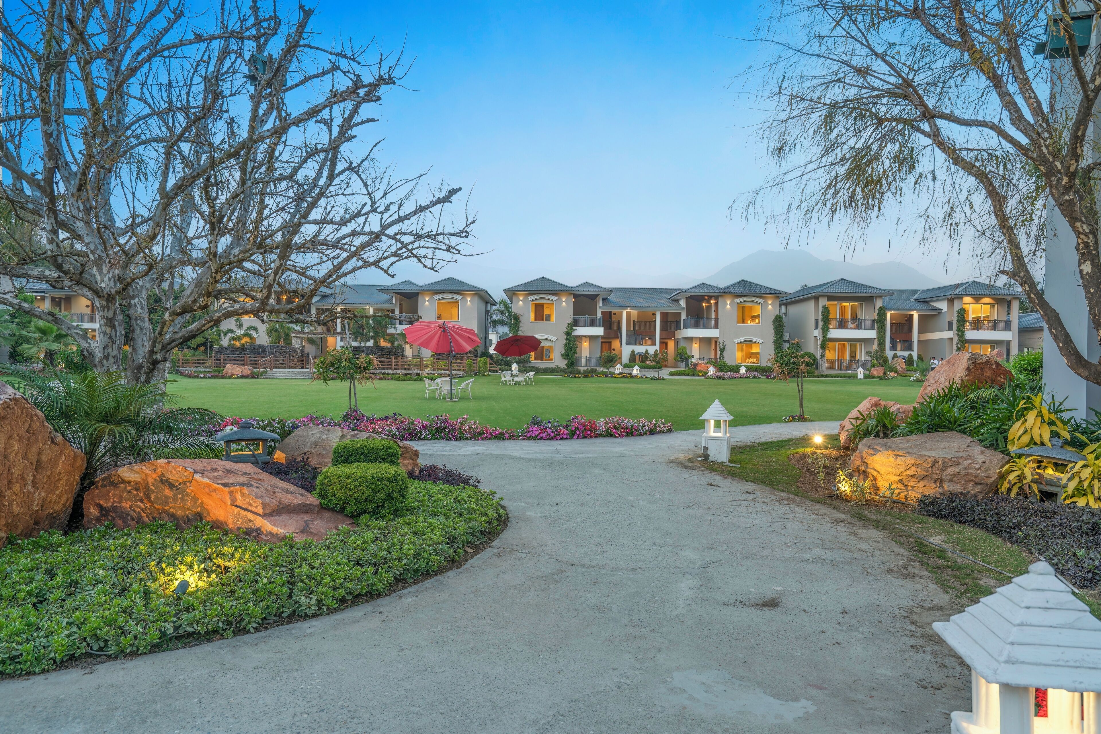 Um hotel com vários edifícios, um gramado bem cuidado e um caminho pavimentado que leva à entrada.