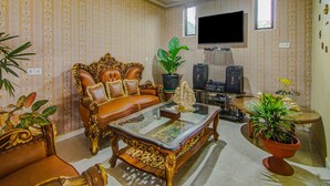 Sala de estar com sofá, mesa de centro e plantas em vasos.