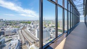 Um edifício alto com grandes janelas que oferecem vista da cidade.