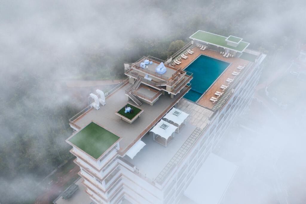 Área de piscina no terraço, com várias espreguiçadeiras e um espaço de estar.