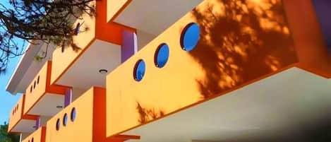 Um edifício moderno com design arquitetônico singular, apresentando vários níveis e janelas circulares.