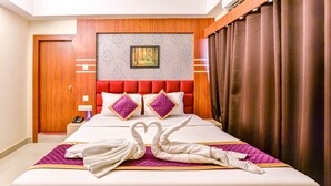 Quarto de hotel com uma cama grande, cabeceira vermelha e uma imagem de uma floresta na parede.
